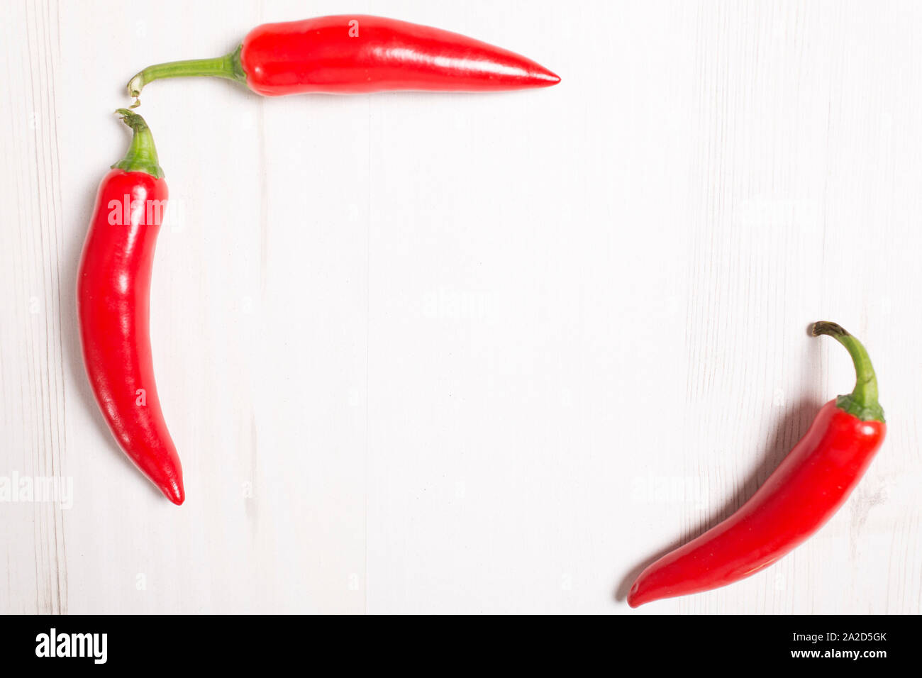 Fresh red chilli on a light wooden kitchen work surface Stock Photo - Alamy