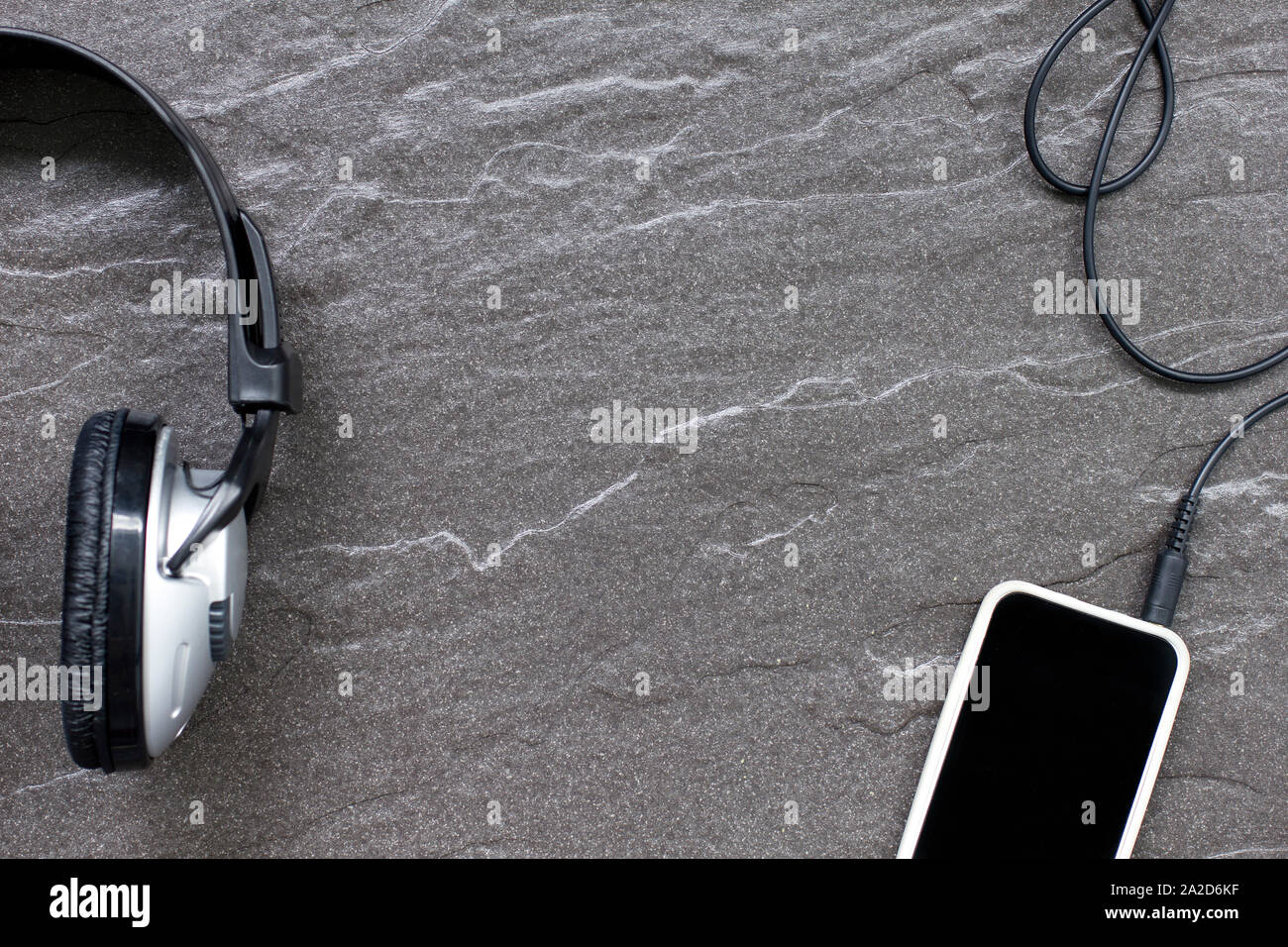 Music headphones on a detailed stone surface with a music player ...