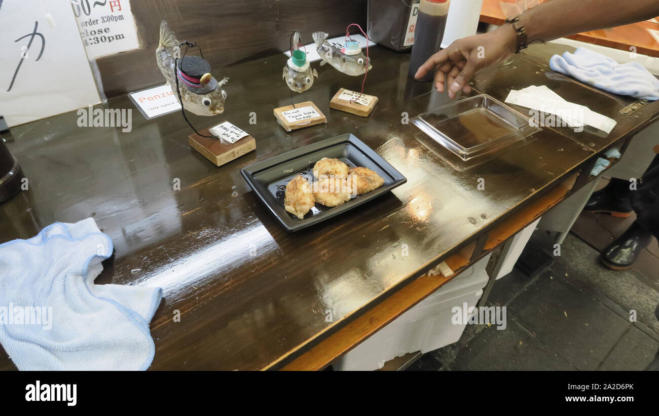 Osaka - 大阪市 - Fogu tasting at Kuromon Ichiba Market Stock Photo - Alamy