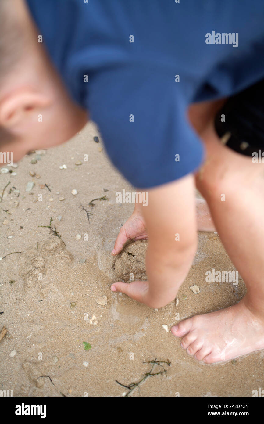 Young boy searching for treasure in the sand and mud Stock Photo - Alamy