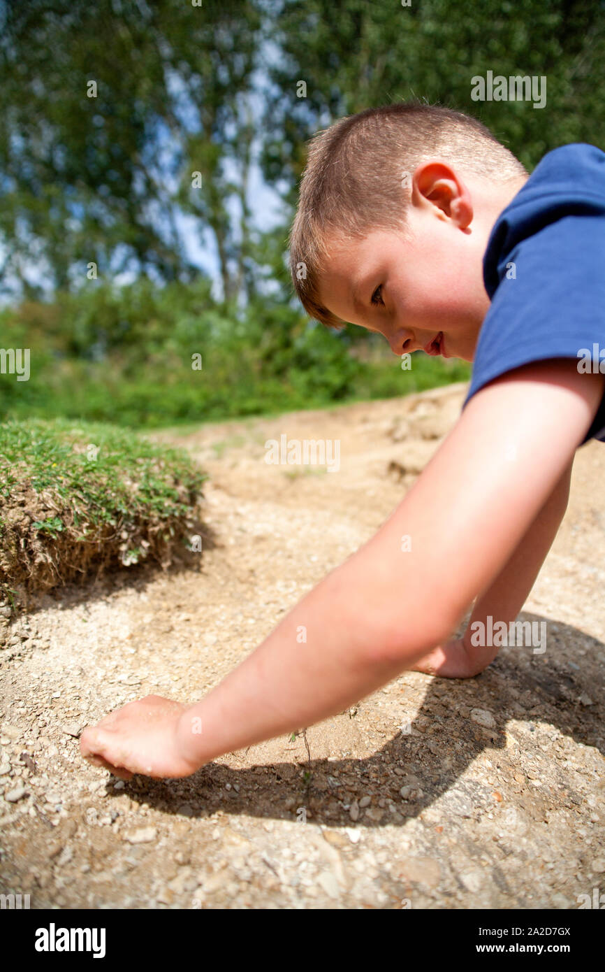 Young boy searching for treasure in the sand and mud Stock Photo - Alamy