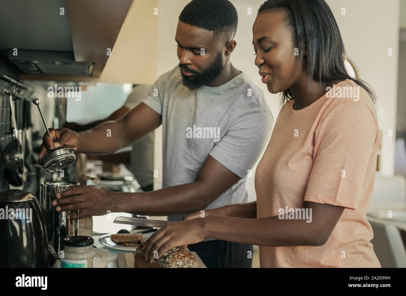 Smiling young African American couple making breakfast together Stock ...