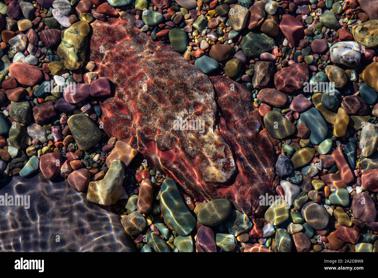 Colorful Rocks in a Glacier Lake during a sunny summer day. Taken in ...