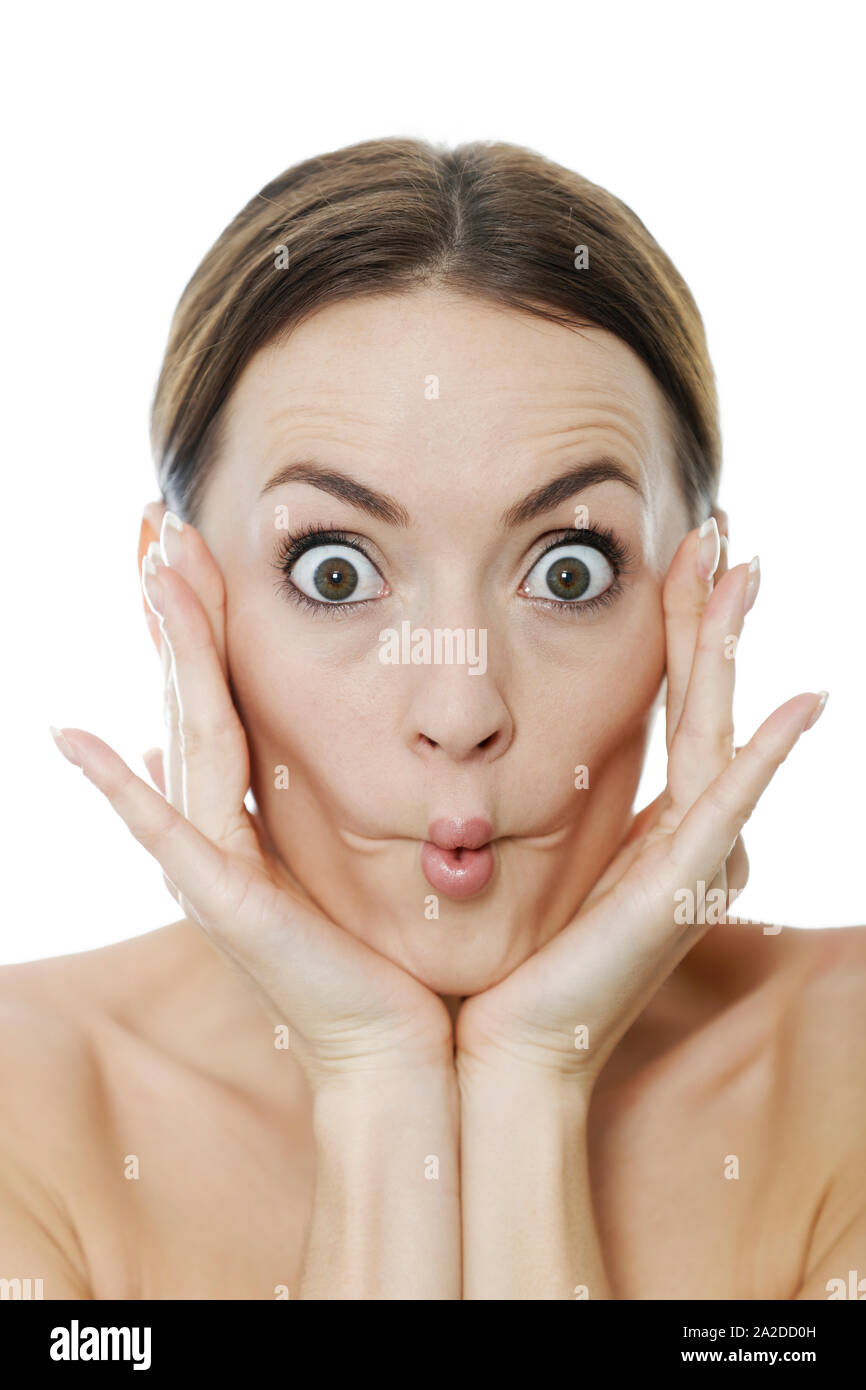 Attractive woman cradling her head in her hands and pulling a face ...