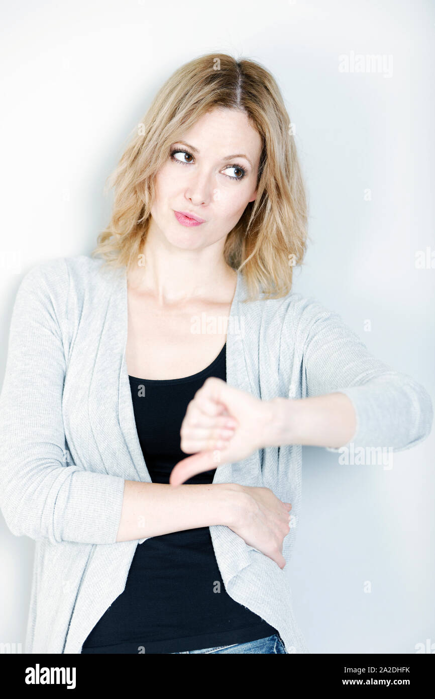 Beautiful young woman in casual blue top looking angry and stressed ...