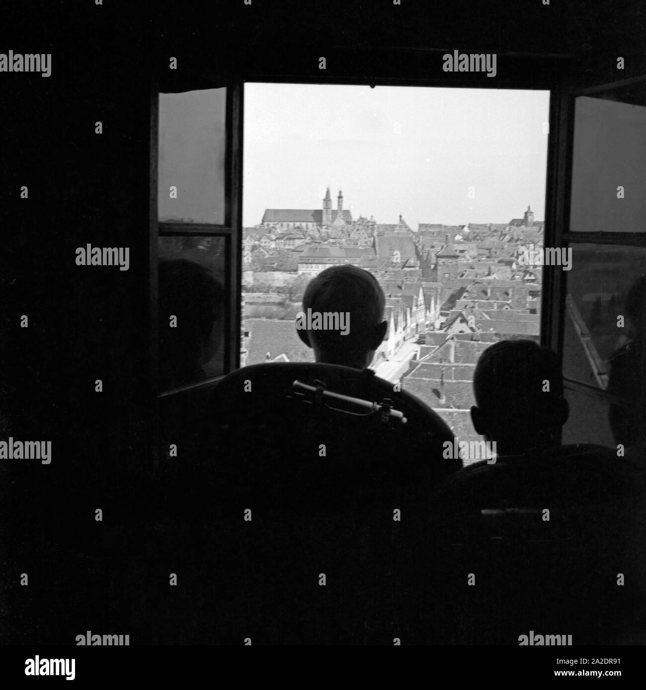 Drei Hitlerjungen schauen aus einem Stadtturmfenster auf die Stadt ...
