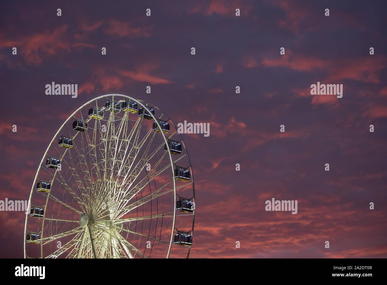 Modern illuminated big wheel with colorful sky Stock Photo - Alamy