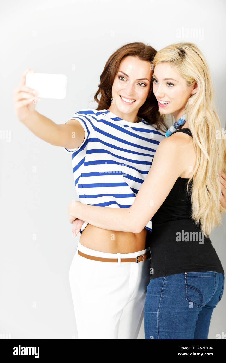 Two good friends having fun with a camera taking a selfie Stock Photo ...