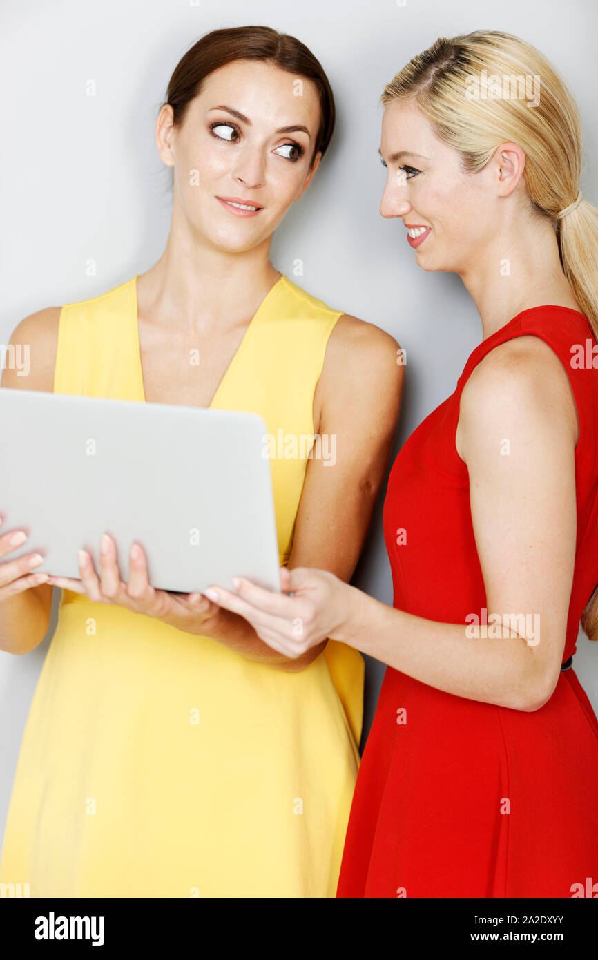 Two beautiful female work colleagues with a laptop computer Stock Photo ...