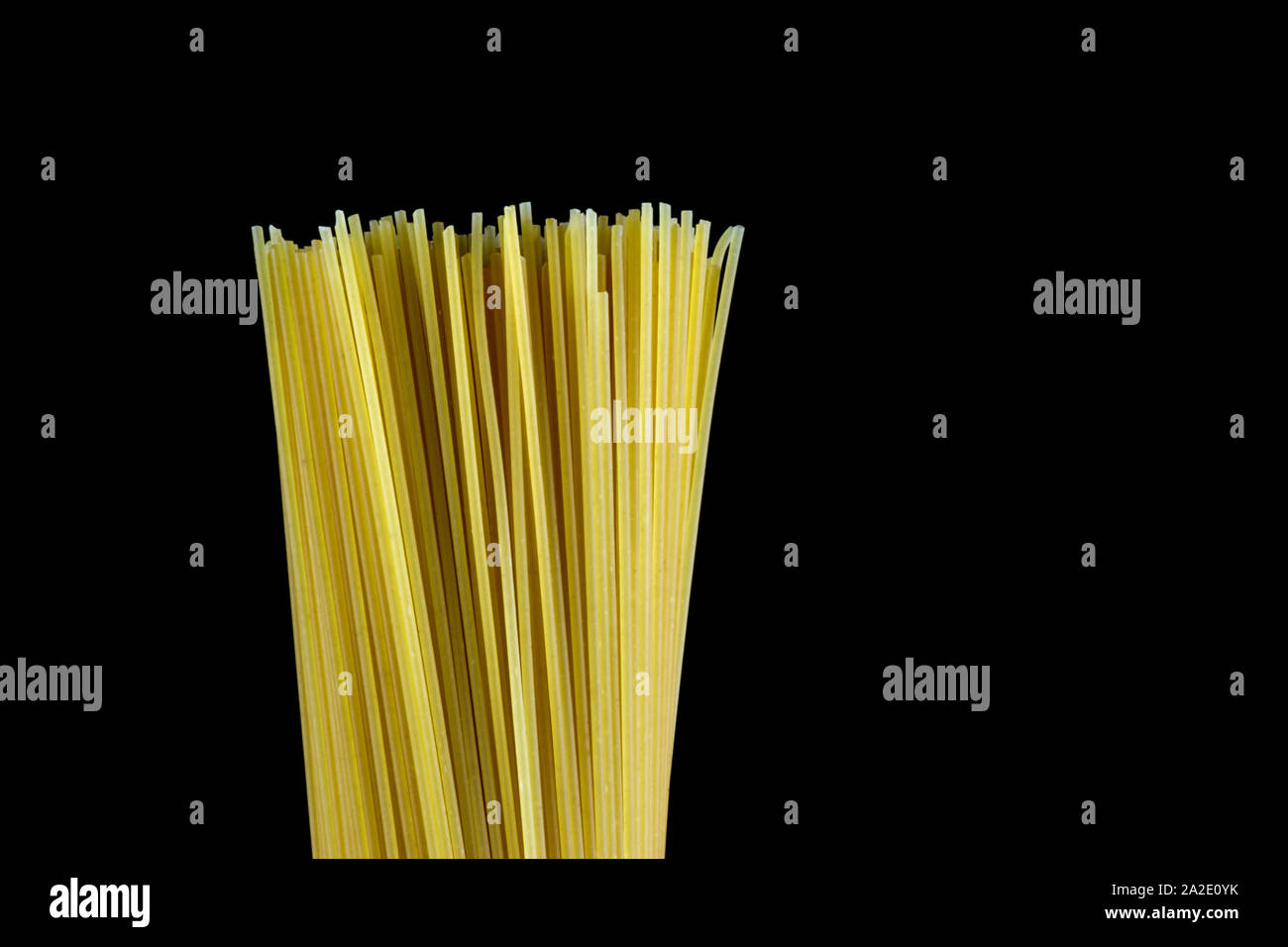 Strips of spaghetti isolated against a black background Stock Photo - Alamy