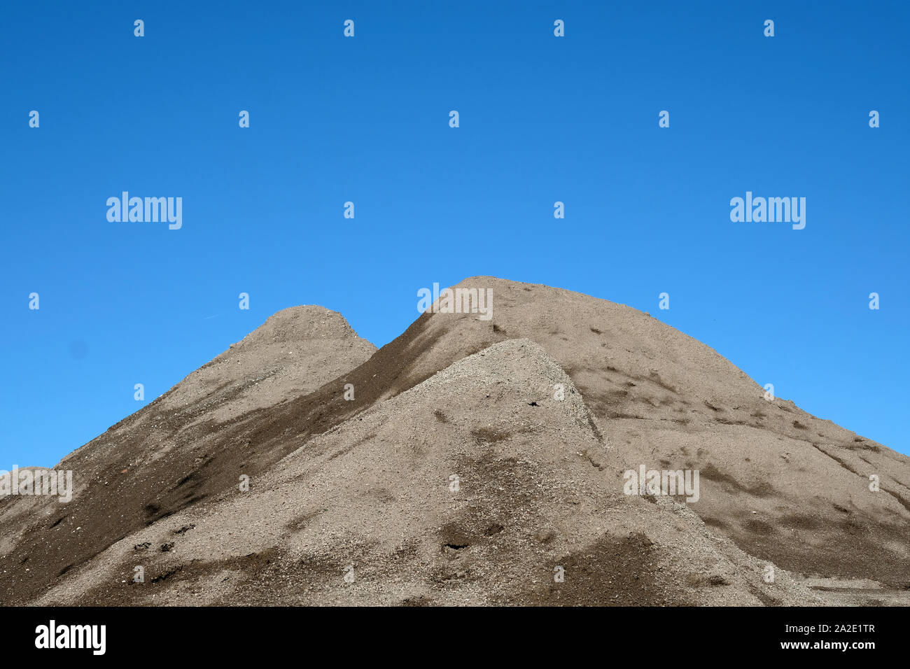 Mountain of grey ash and grit against a blue sky Stock Photo - Alamy