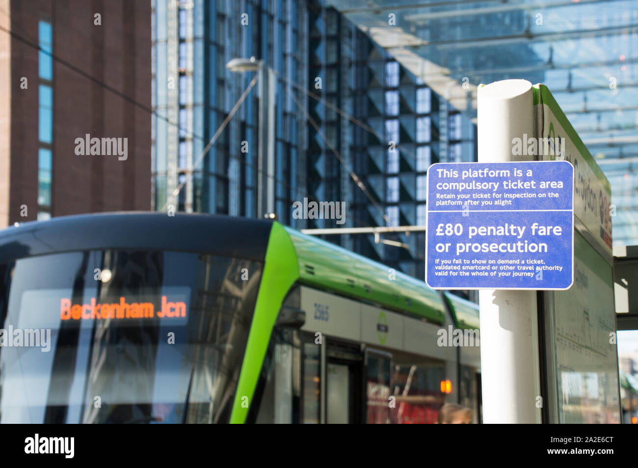 Penalty fare warning sign at TFL operated tram platform with tram on ...
