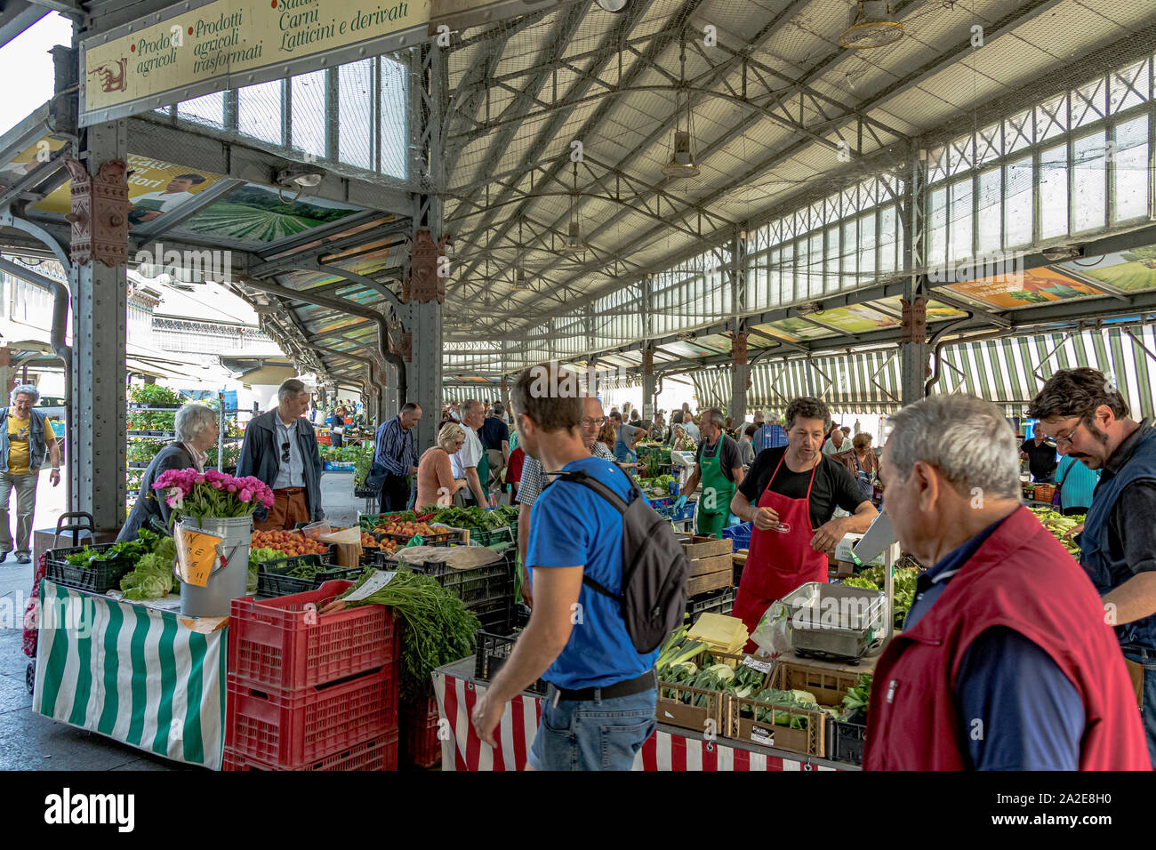 People shopping for fresh produce inside one of the covered market ...