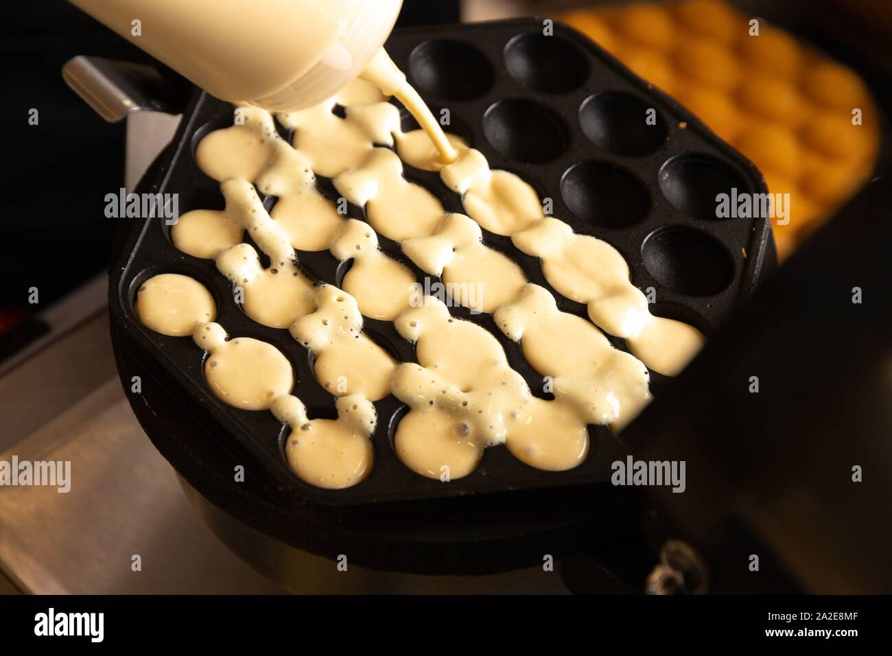 Making waffles on dark waffle iron, action shots Stock Photo - Alamy