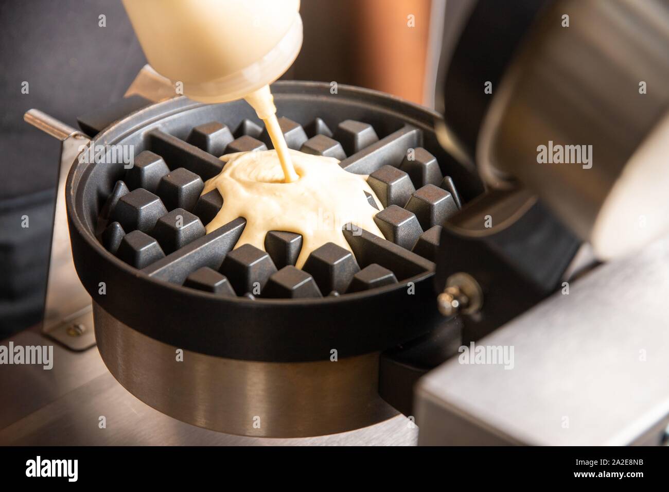 Making waffles on dark waffle iron, action shots Stock Photo - Alamy