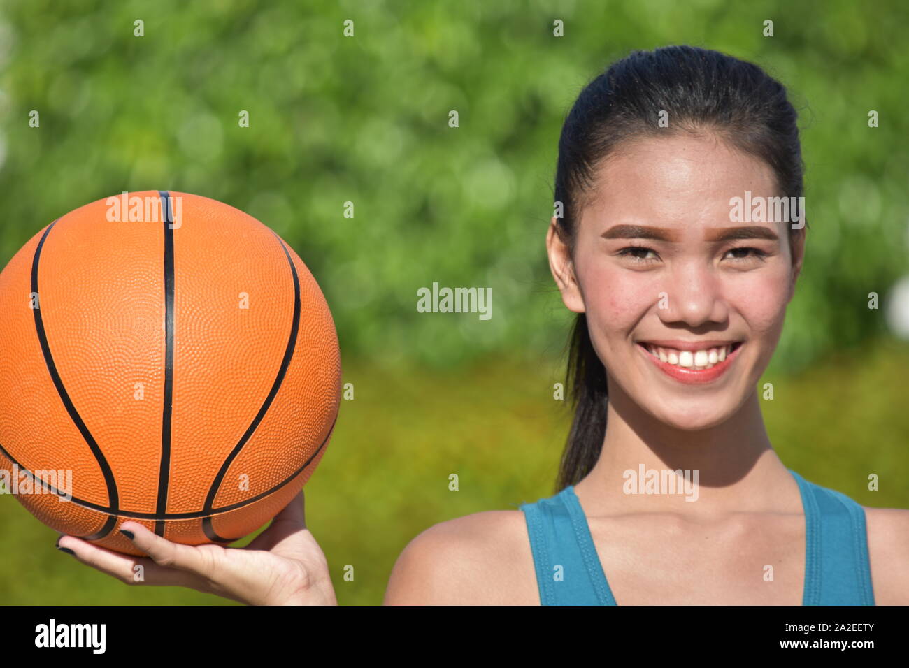 Smiling Sporty Female Basketball Player With Basketball Stock Photo - Alamy