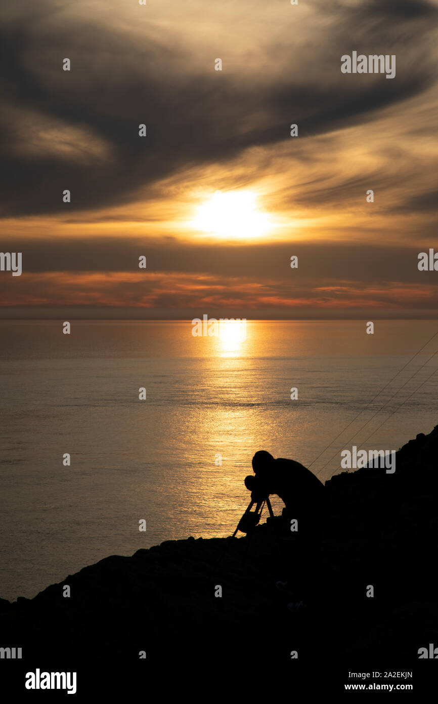 Sunset at South Stack with silhouette of photographer Stock Photo - Alamy
