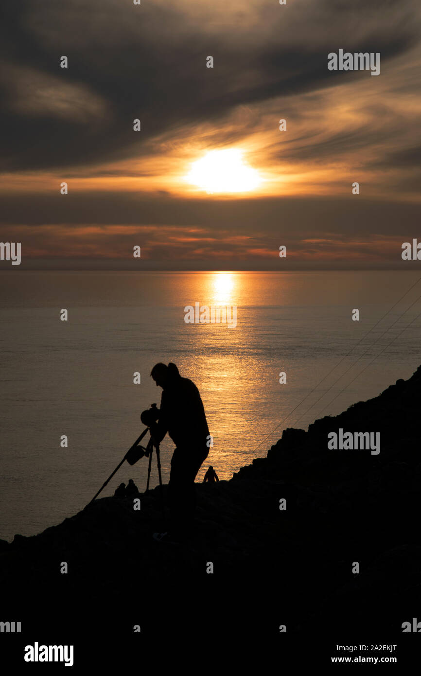 Sunset at South Stack with silhouette of photographer Stock Photo - Alamy