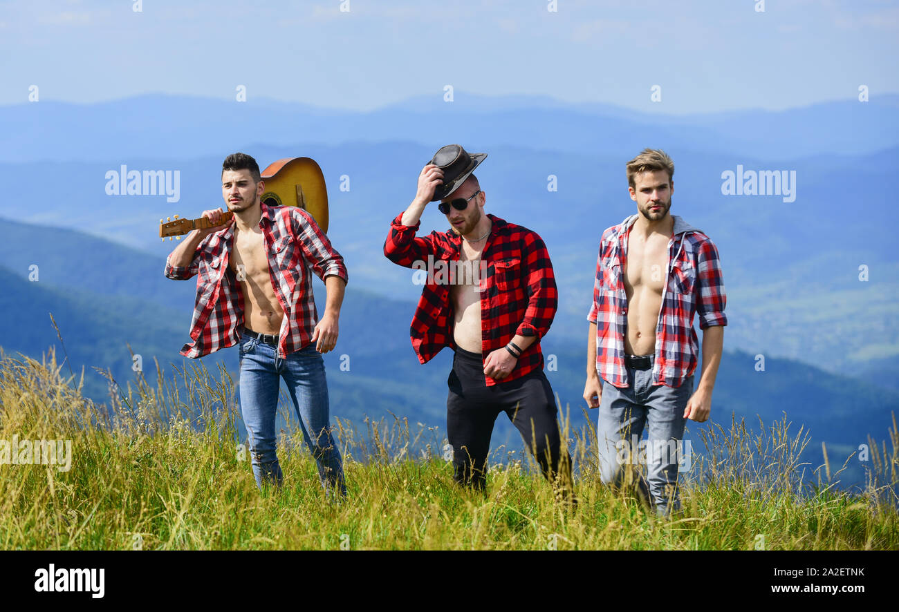 Friendly guys with guitar hiking on sunny day. Enjoying freedom ...