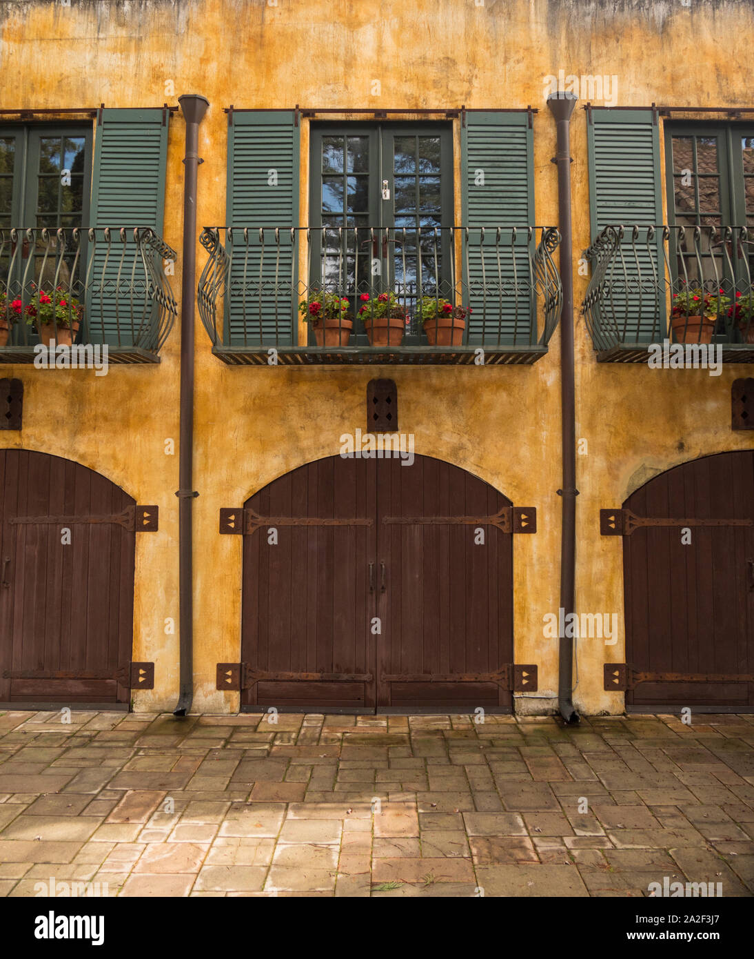 Italian style two-story building with doors and terrace balcony above ...