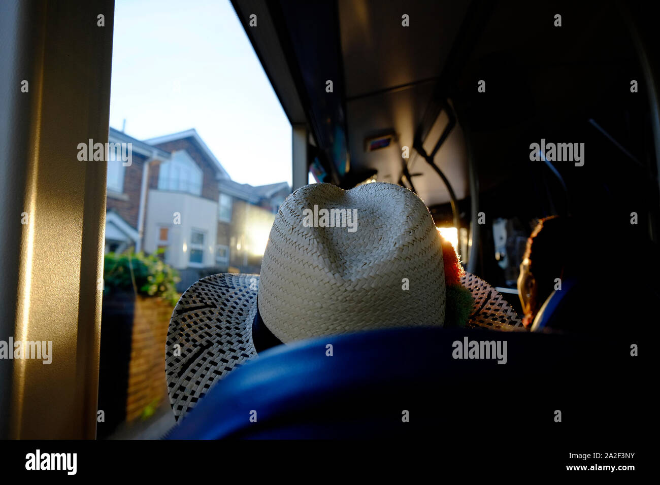 Bus passenger's view out of the window from behind a passenger wearing ...