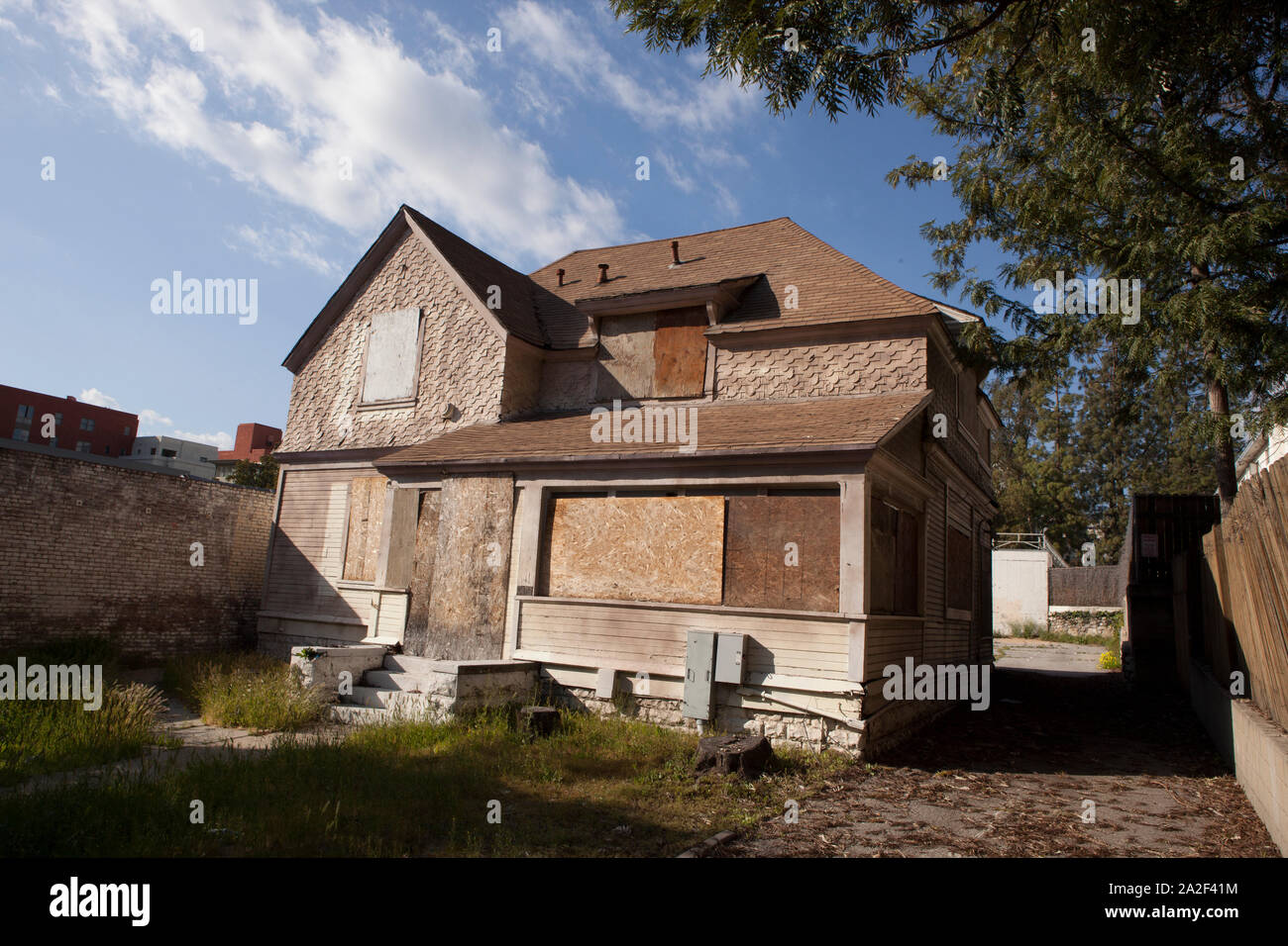 An old boarded up house sits vacant in the middle of the city Stock ...
