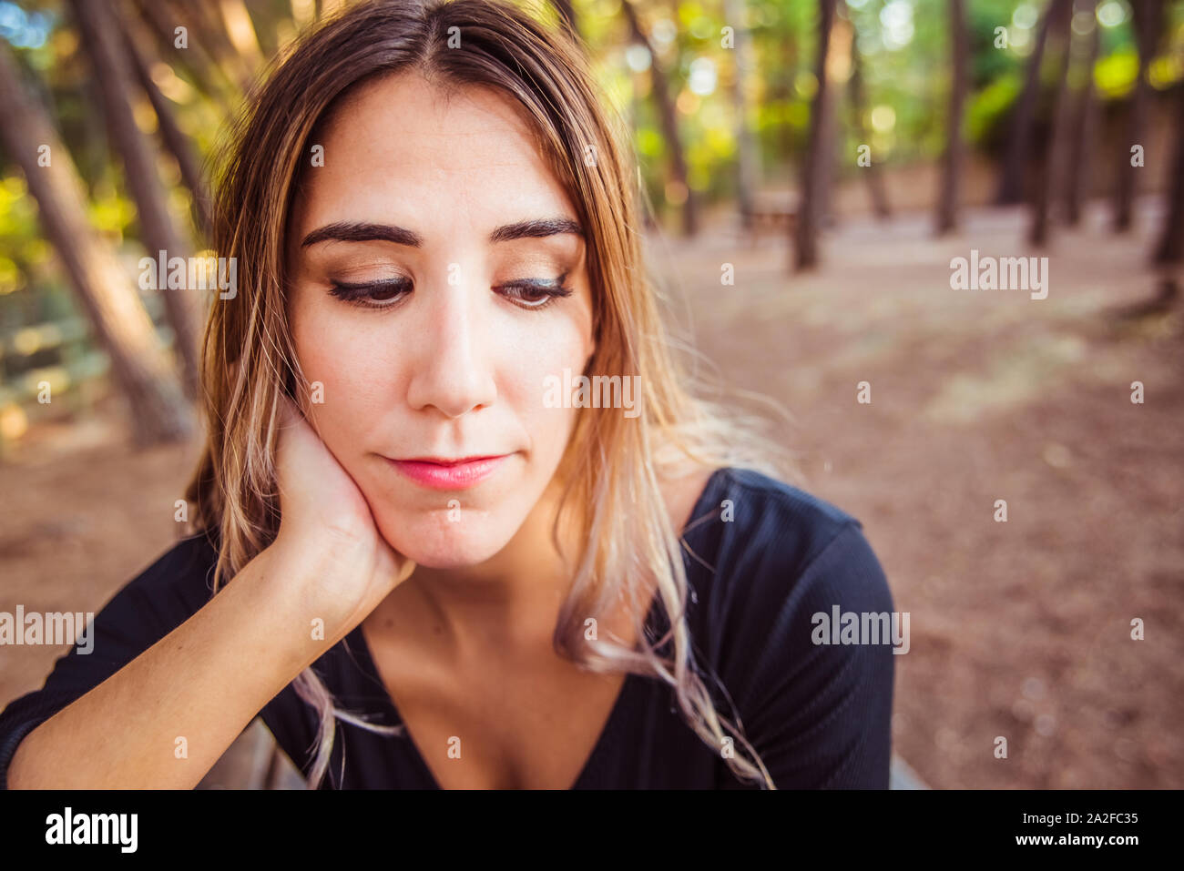 Portrait of young woman studying with thoughtful appearance Stock Photo ...