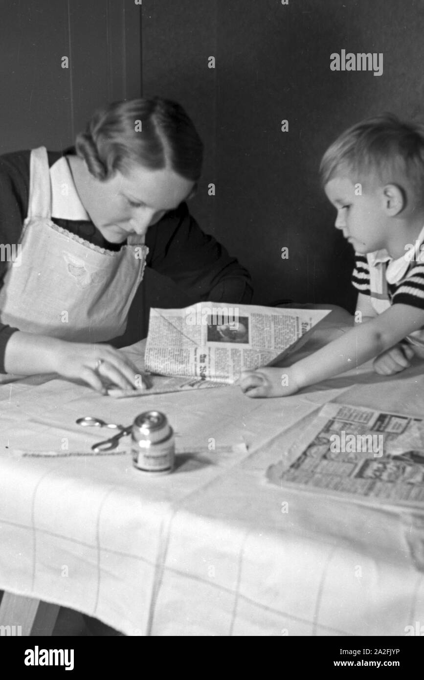 Mutter und Kind beim basteln, Deutschland 1930er Jahre. Mother and ...