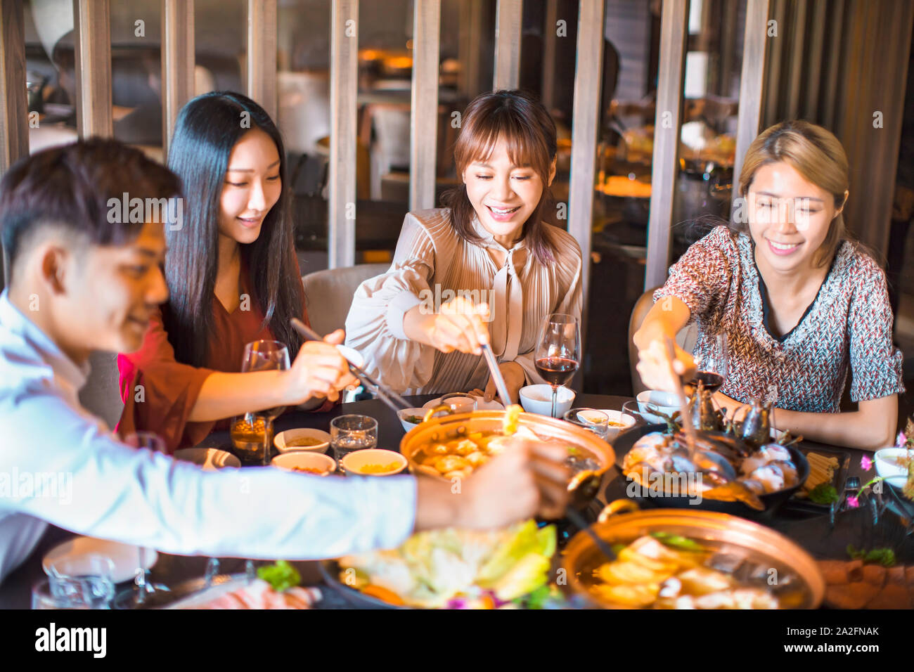 Happy friends having fun in hot pot restaurant Stock Photo - Alamy