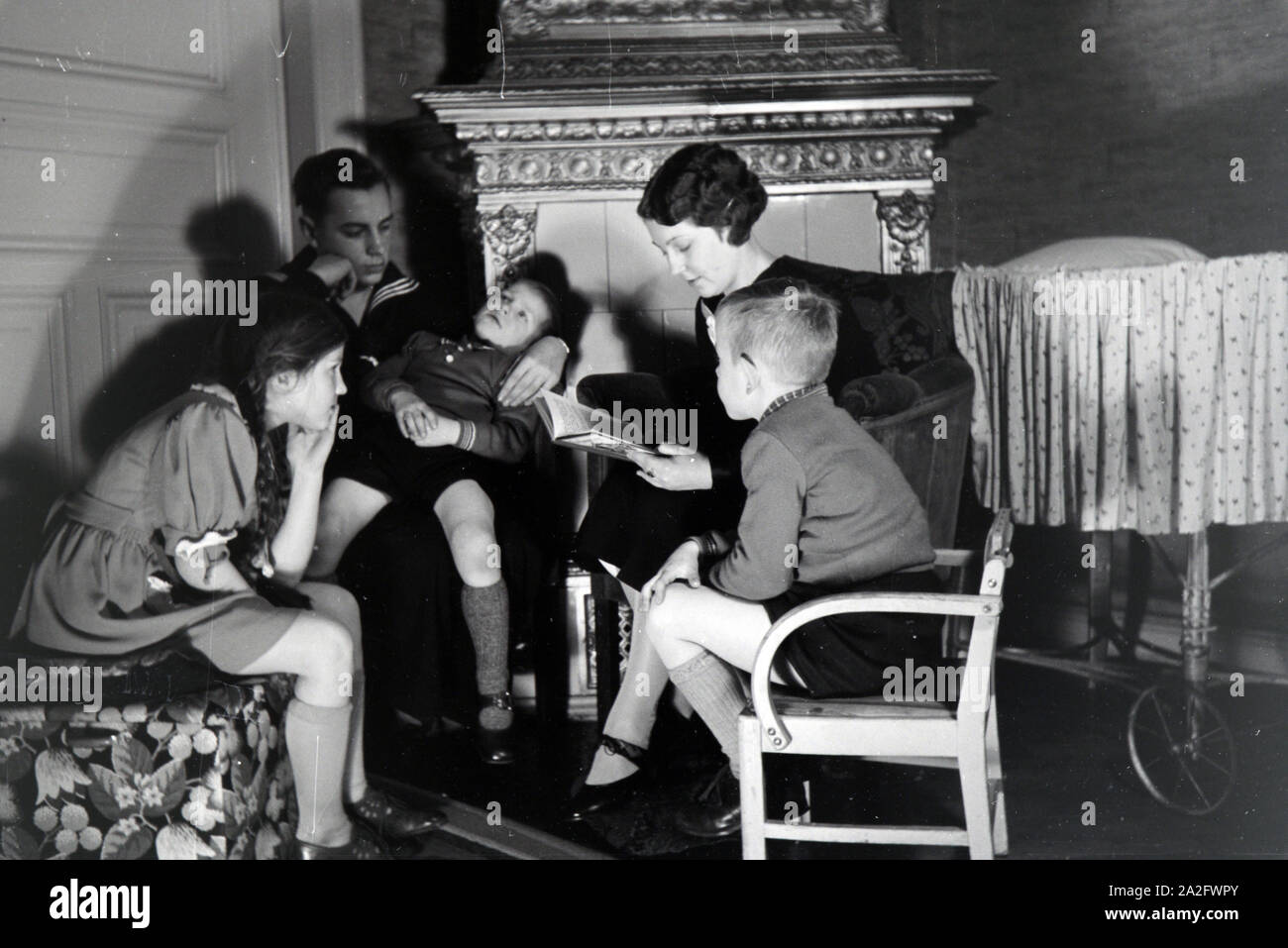 Mitglieder einer kinderreichen Familie lesen gemeinsam ein Buch ...