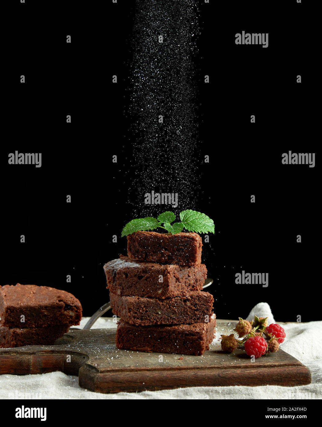 stack of square baked brownie chocolate cake slices sprinkled with ...