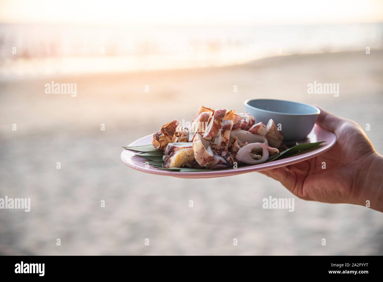 Grilled squid plate on beach sea background Stock Photo - Alamy