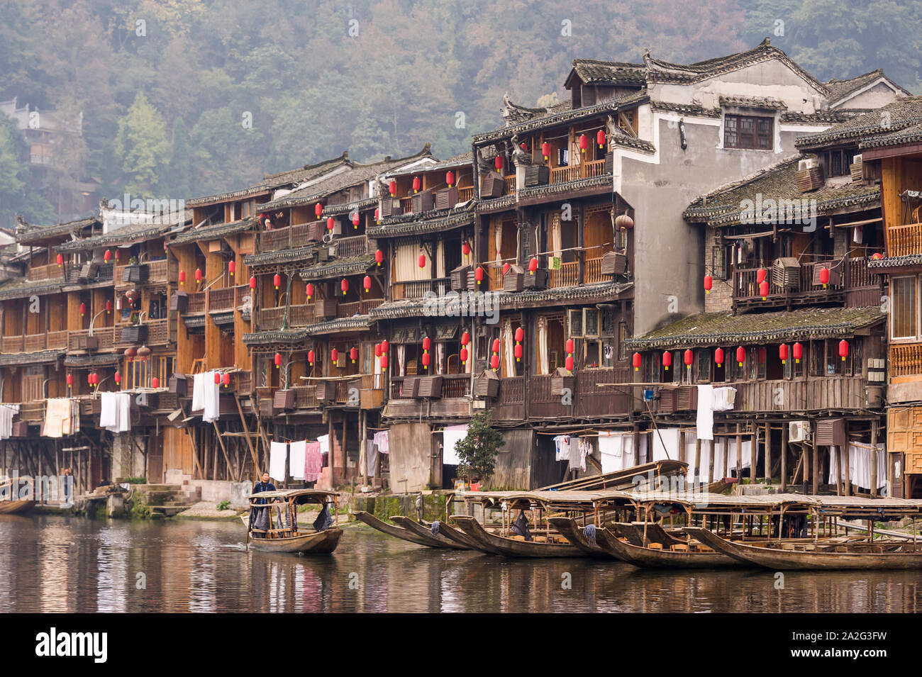 Hunan, China, 14 Nov 2011: Man rowing wooden boat along river of ...