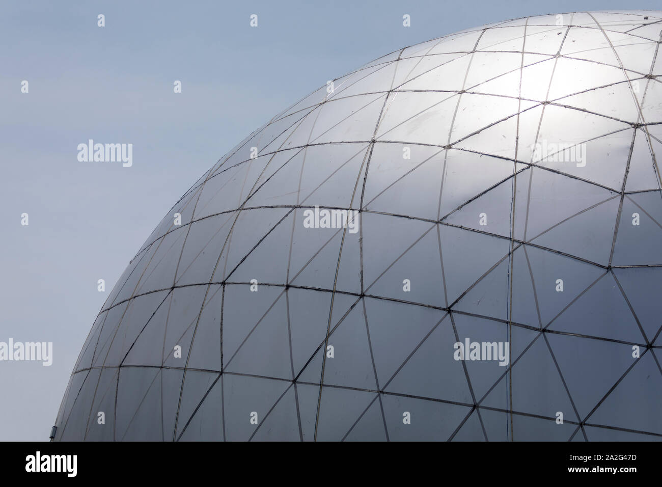 Space Age Modern Silver Dome Structure With Hexagonal And Triangular Patterns Against A Blue Sky