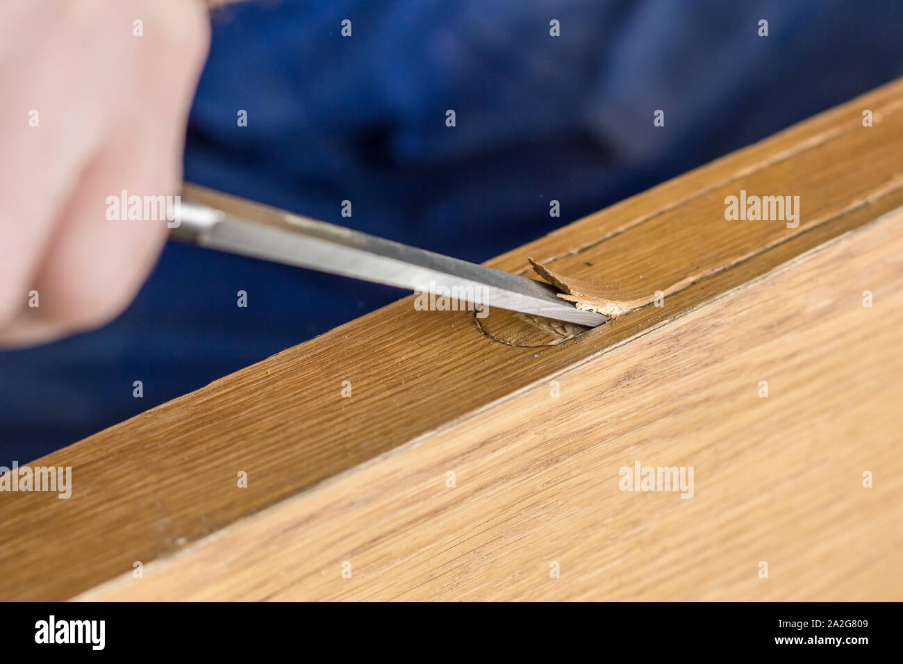 Carpenter makes a hole in old wooden door for the mortise lock with a ...