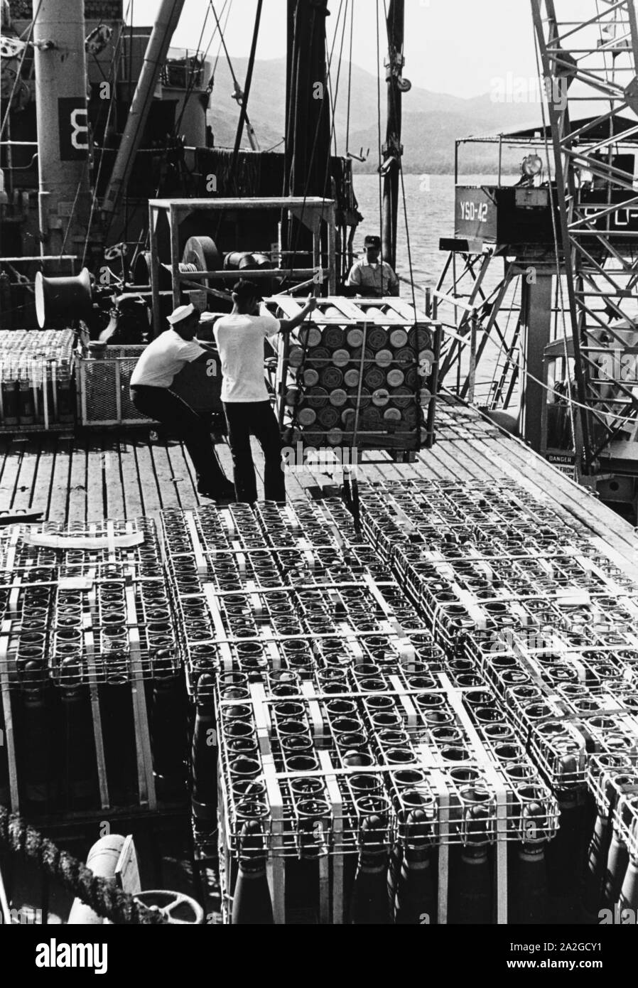 Empty 127 mm shell casings are loaded on USS Mattaponi (AO-41) off ...