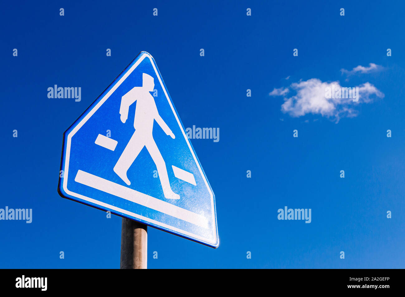 Blue Crosswalk pedestrian crossing sign against blue sky with copy ...