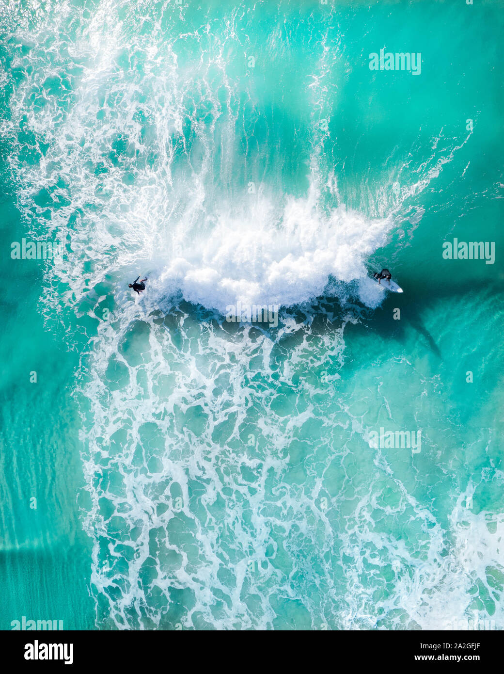 Surfers enjoying massive waves at sunrise in the ocean. Beautiful ...