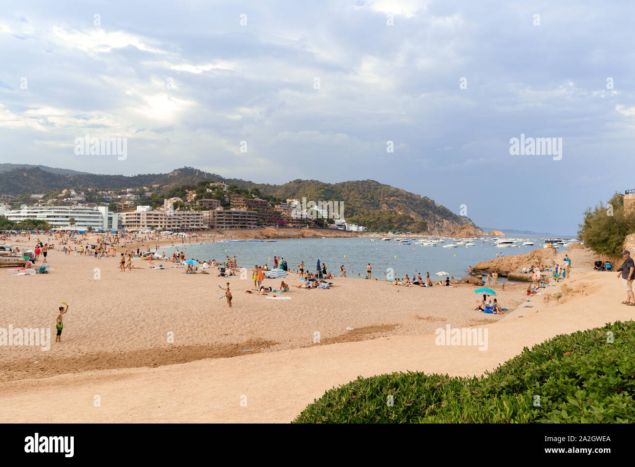 TOSSA DE MAR, SPAIN - AUGUST 7, 2019: Sunbathing people on a central ...