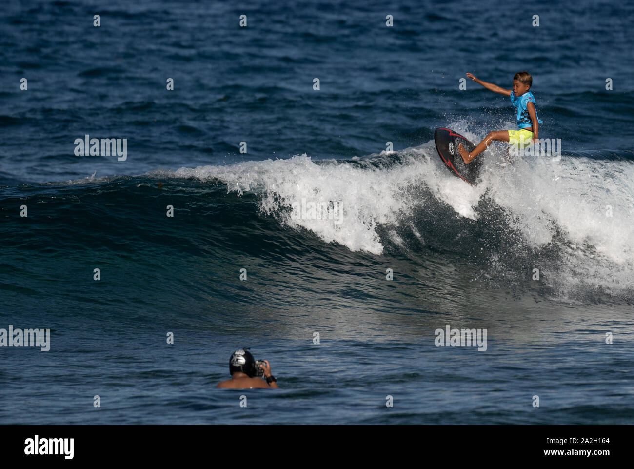 A young boy surfing at Cloud 9 surf break,Siargao,Philippines Stock ...