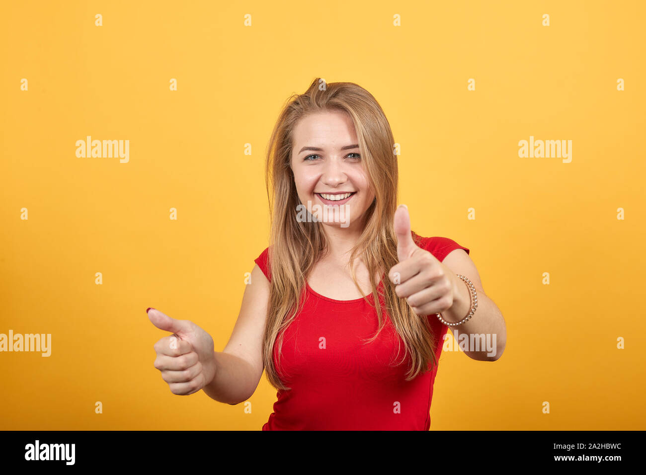 Young Blonde Girl In Red T Shirt Over Isolated Orange Background Shows