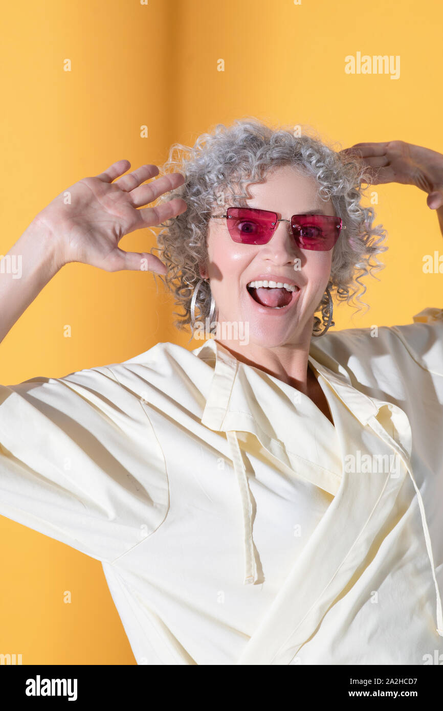 Curly Haired Pretty Woman Wearing Bright Sunglasses Laughing Stock