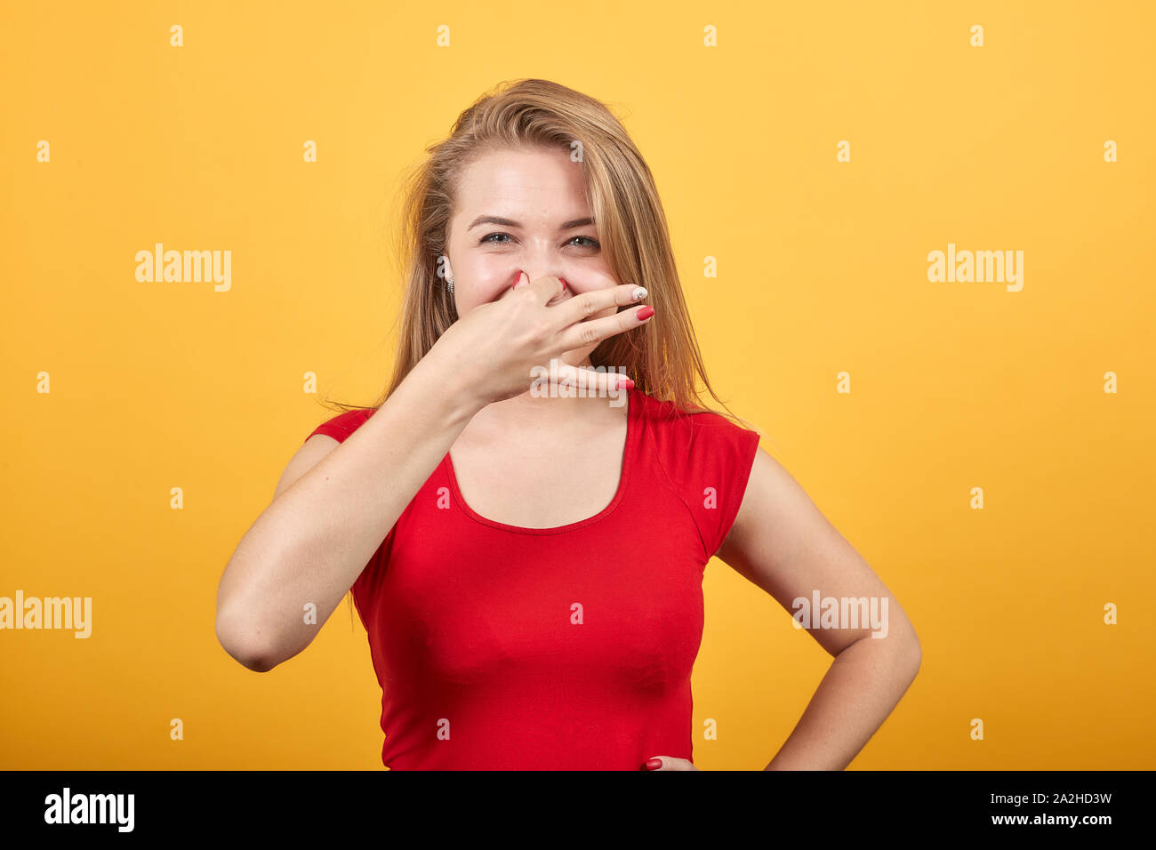 Young Blonde Girl In Red T Shirt Over Isolated Orange Background Shows