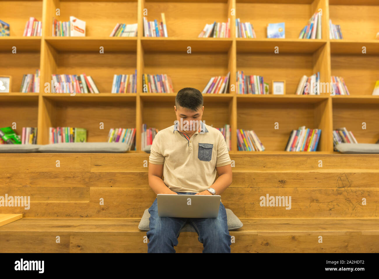 Asian student using laptop at wooden library bookshelf background Stock ...