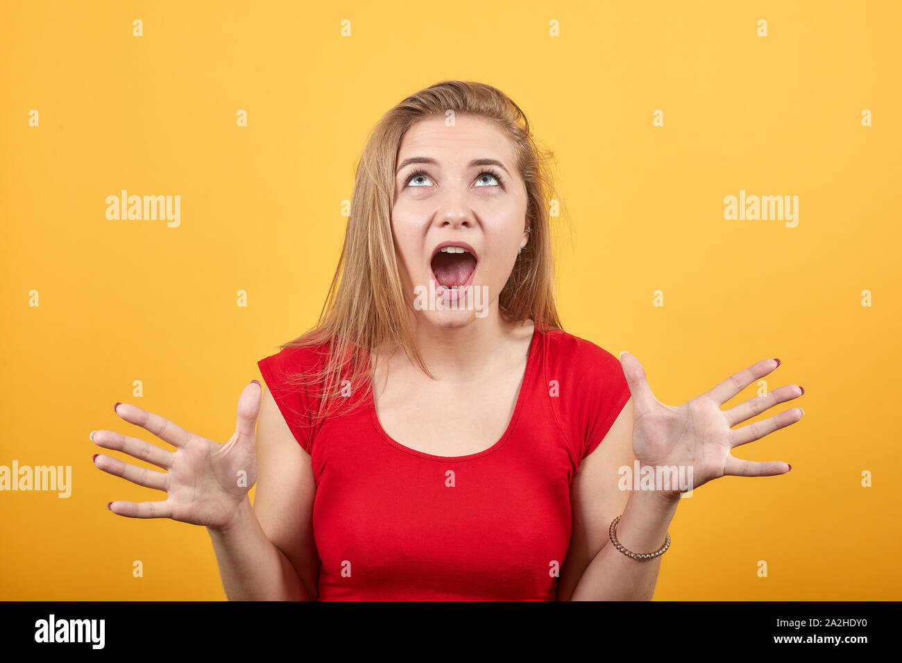 Young Blonde Girl In Red T Shirt Over Isolated Orange Background Shows