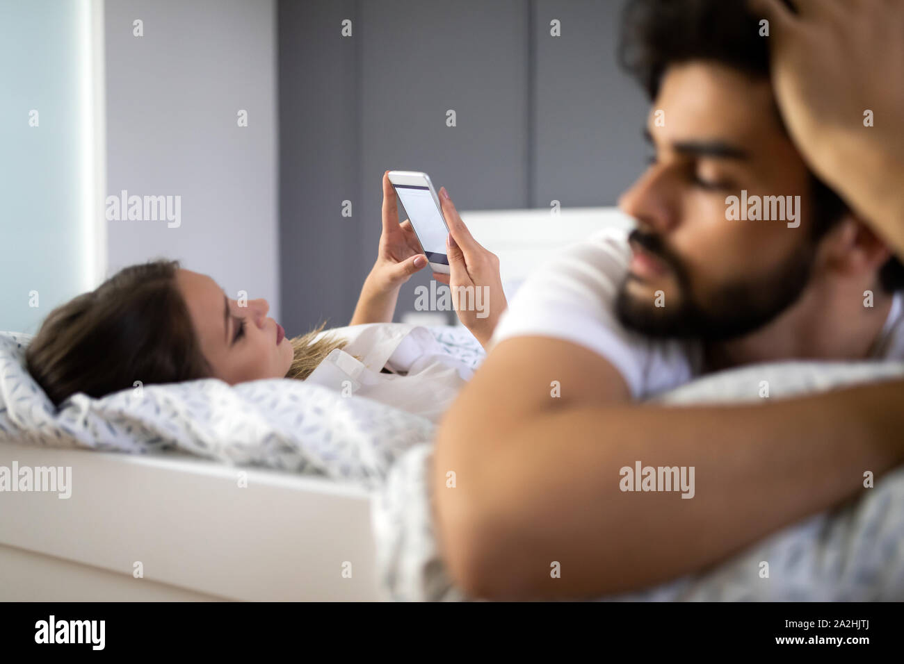 Unhappy couple ignoring each other using mobile phone Stock Photo - Alamy
