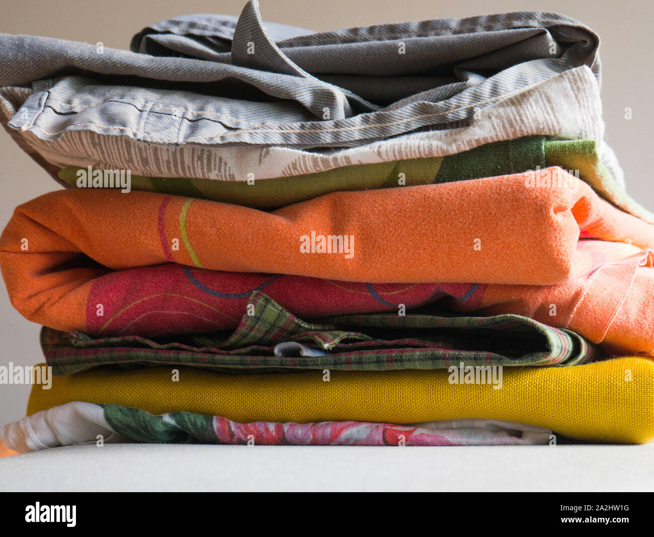 Pile of clothes for ironing. Stack of clothes Stock Photo - Alamy