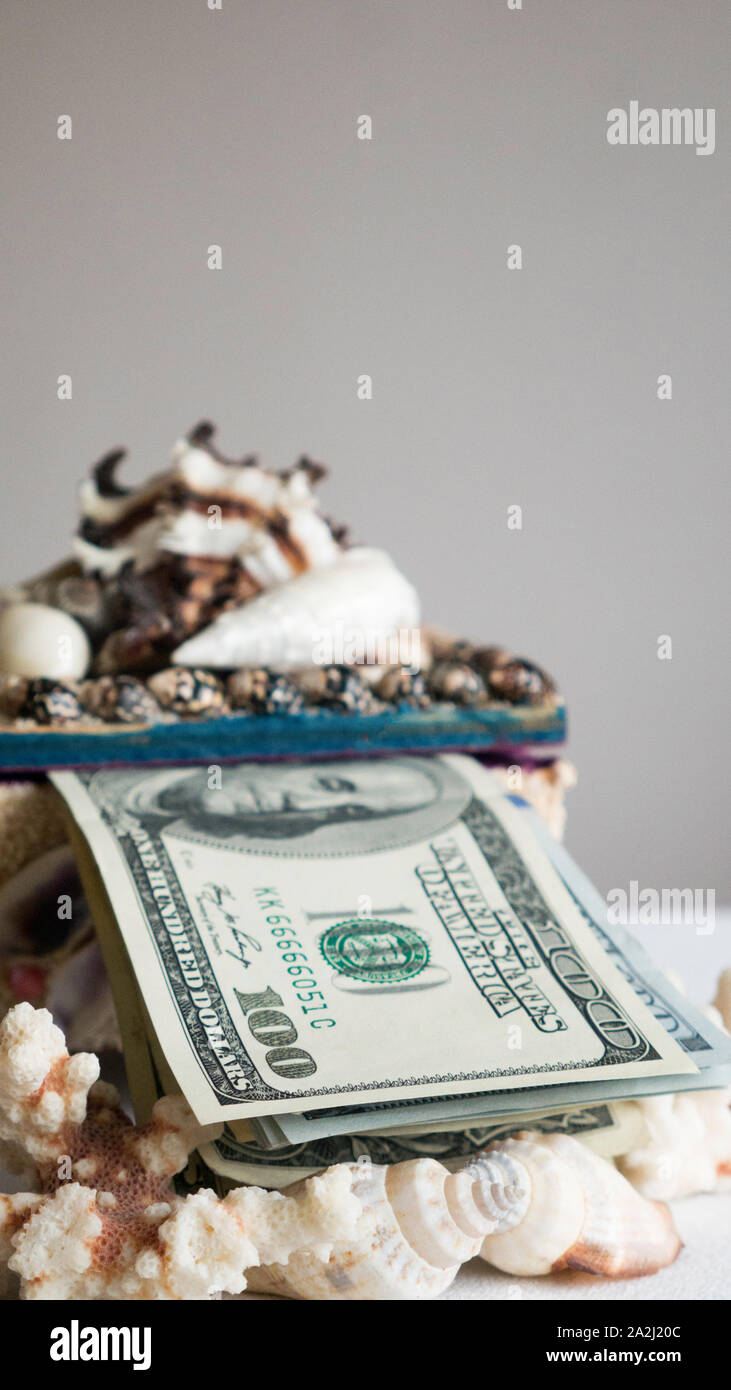 Stack of one hundred dollar bills in a box of seashells Stock Photo - Alamy