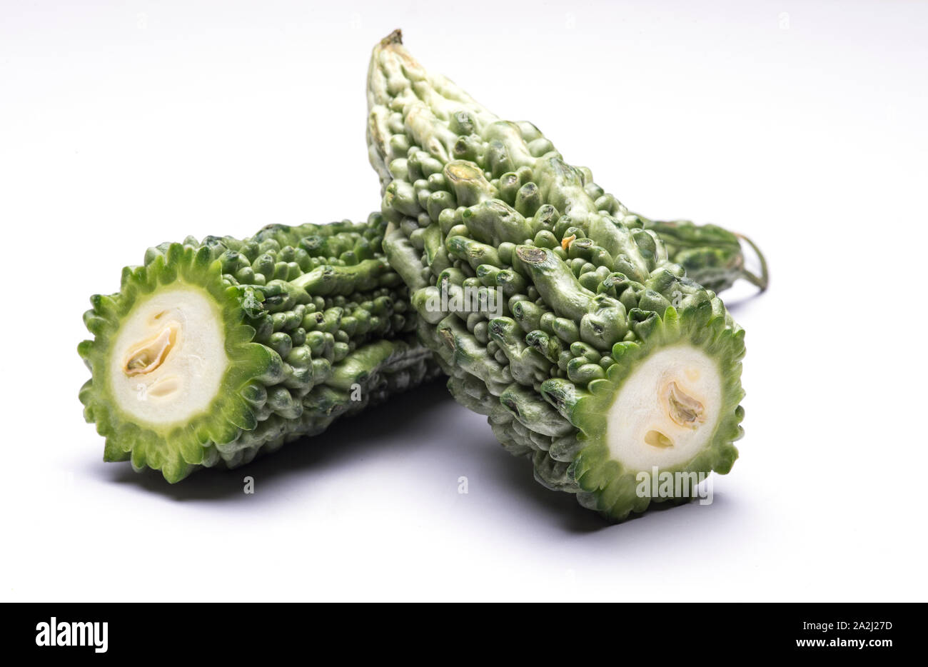 Bitter gourd cut in halves on isolated white background Stock Photo - Alamy