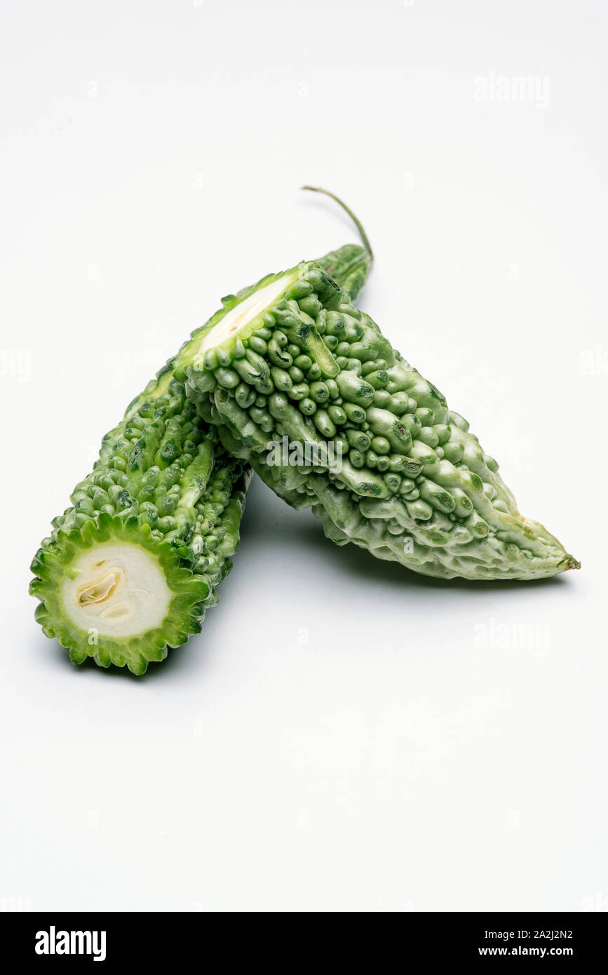 Bitter gourd cut in halves on isolated white background Stock Photo - Alamy